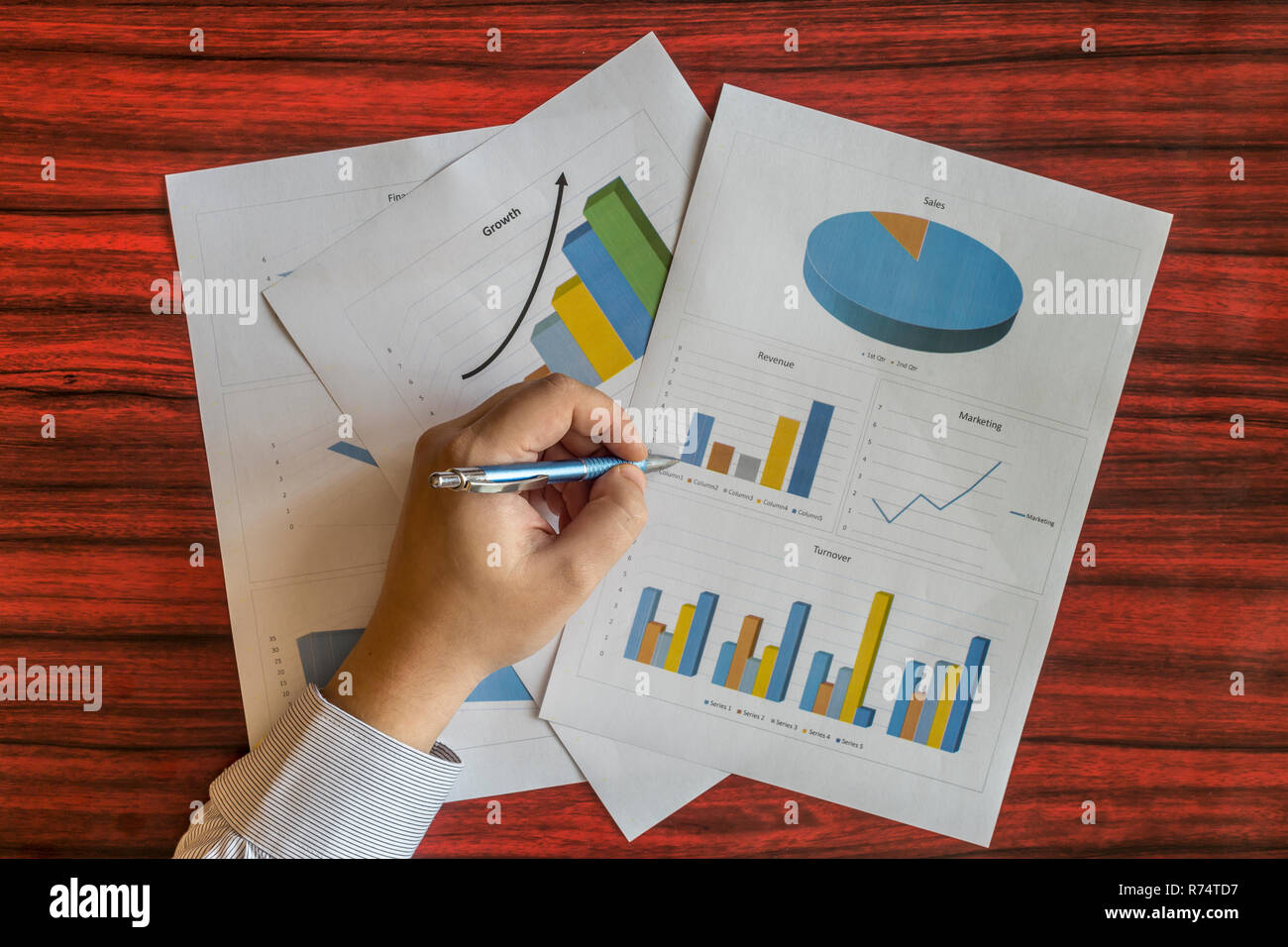 Left handed person analyzing charts Stock Photo - Alamy