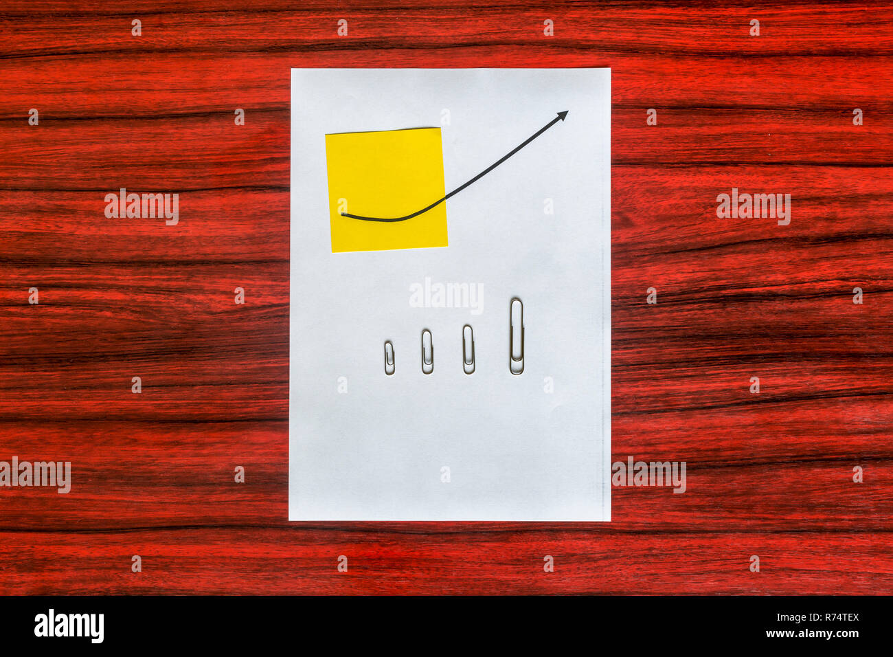 Curve graph printed on a sheet of paper and yellow note with arranged ...