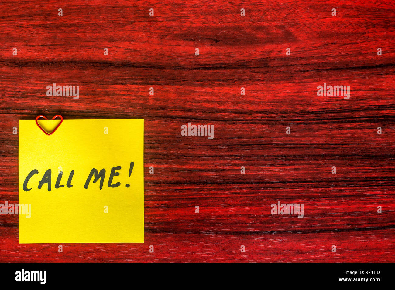 Heart shaped paper clip on a yellow sticky note with the words Call me ...