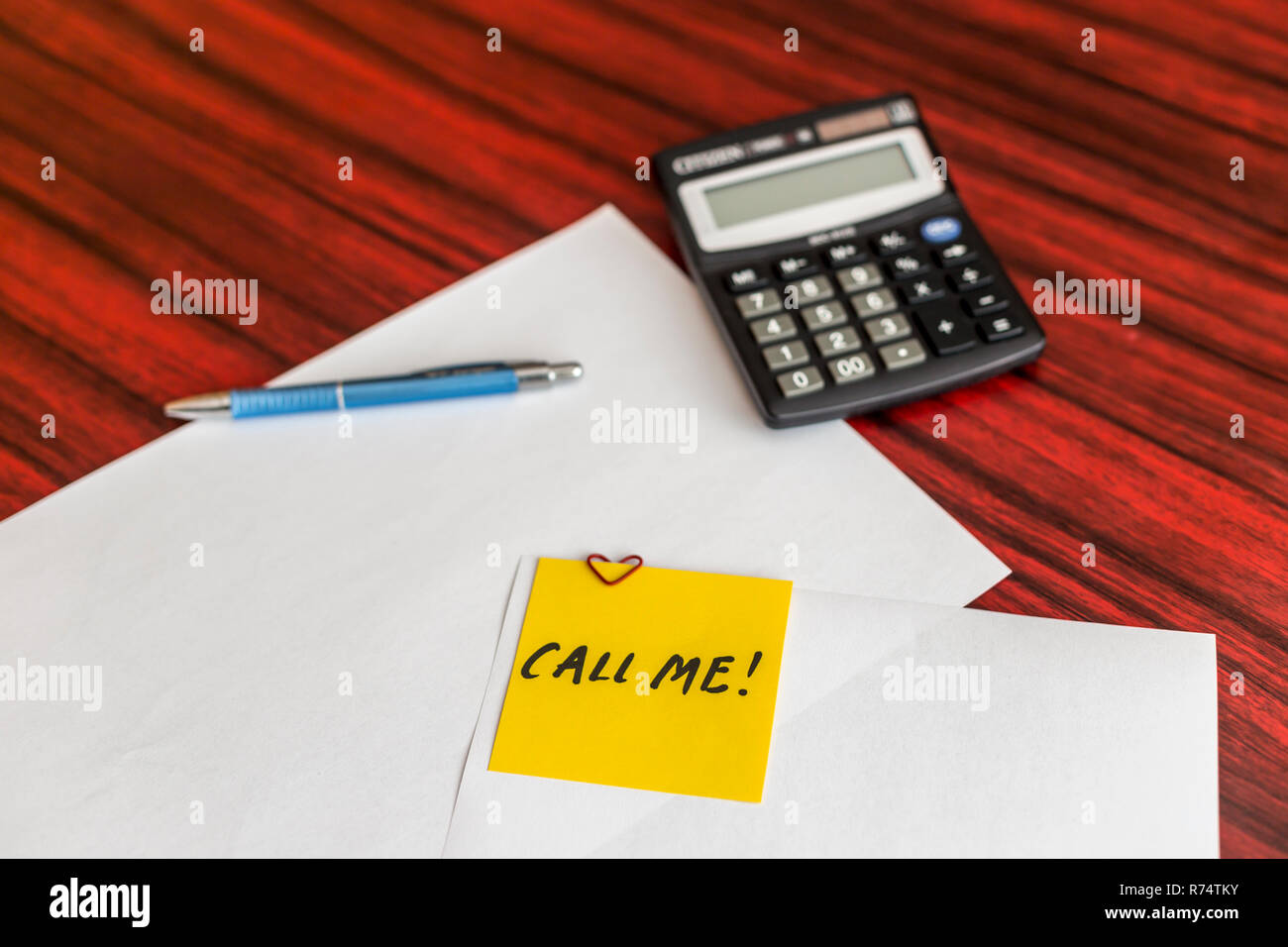 Yellow note with the words Call me written on it. The note is attached ...