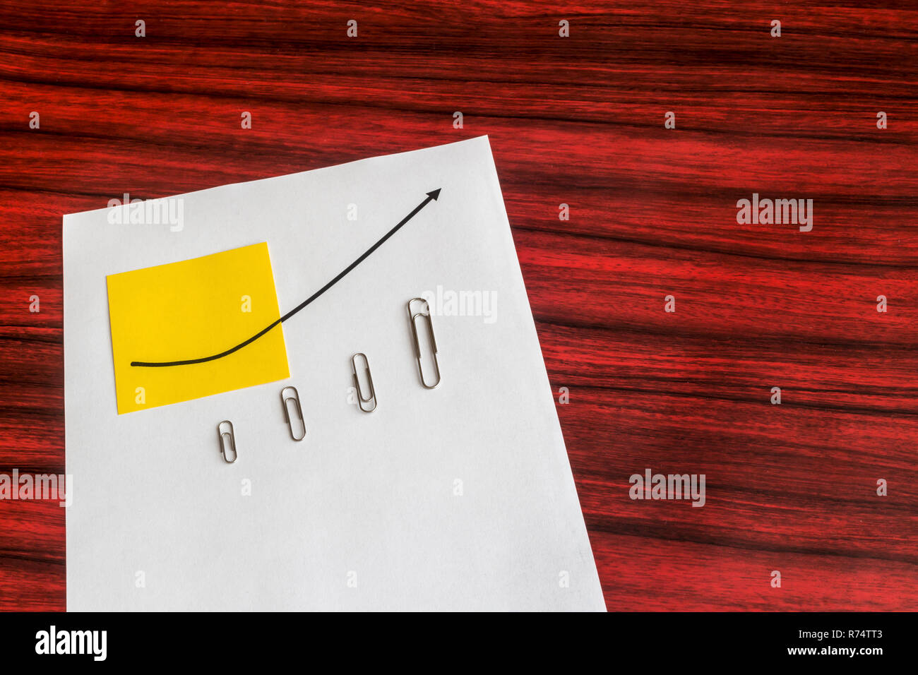 Curve graph printed on a sheet of paper and yellow note with arranged ...