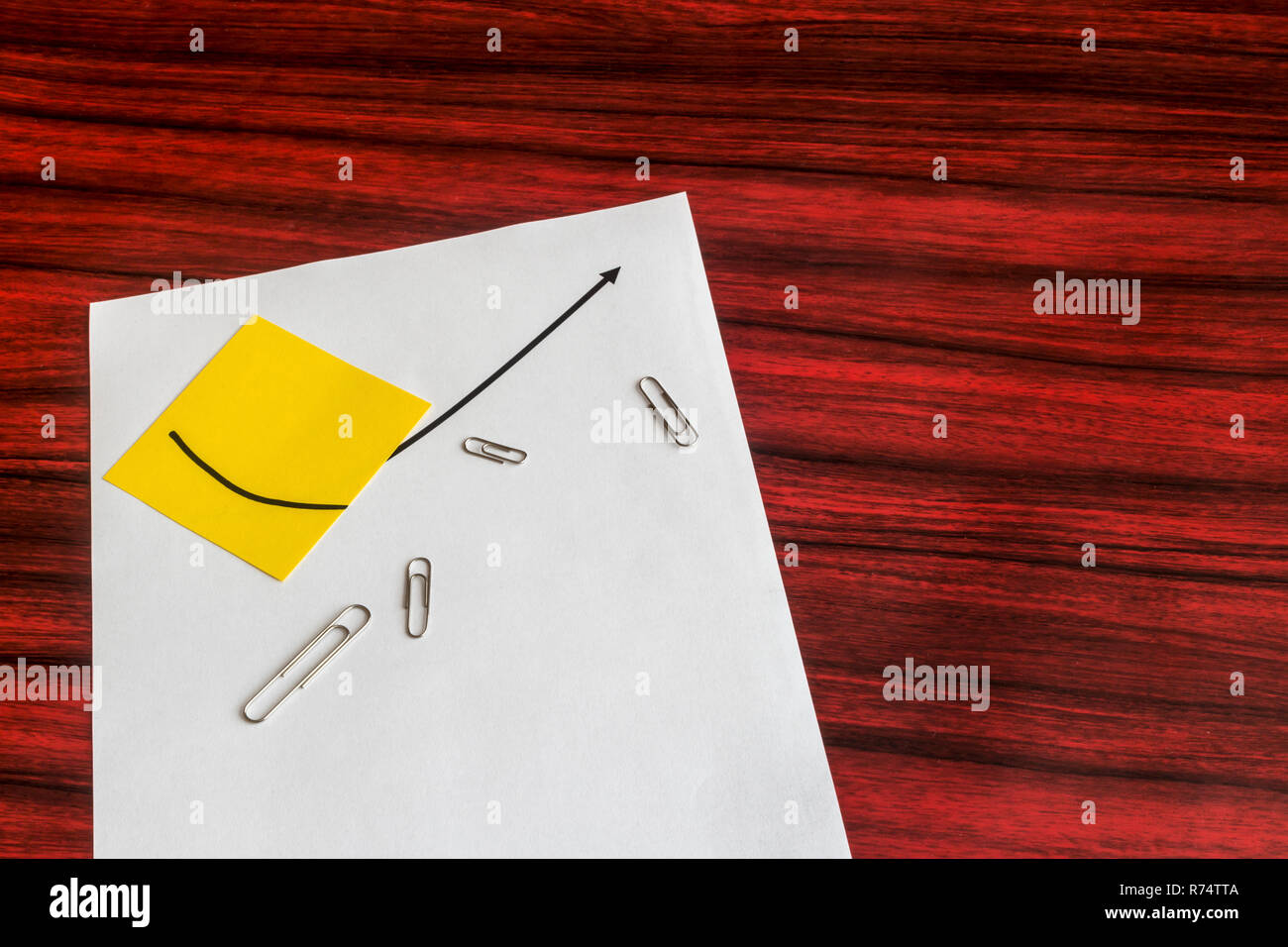 Curve graph printed on a sheet of paper and yellow note with spreaded ...