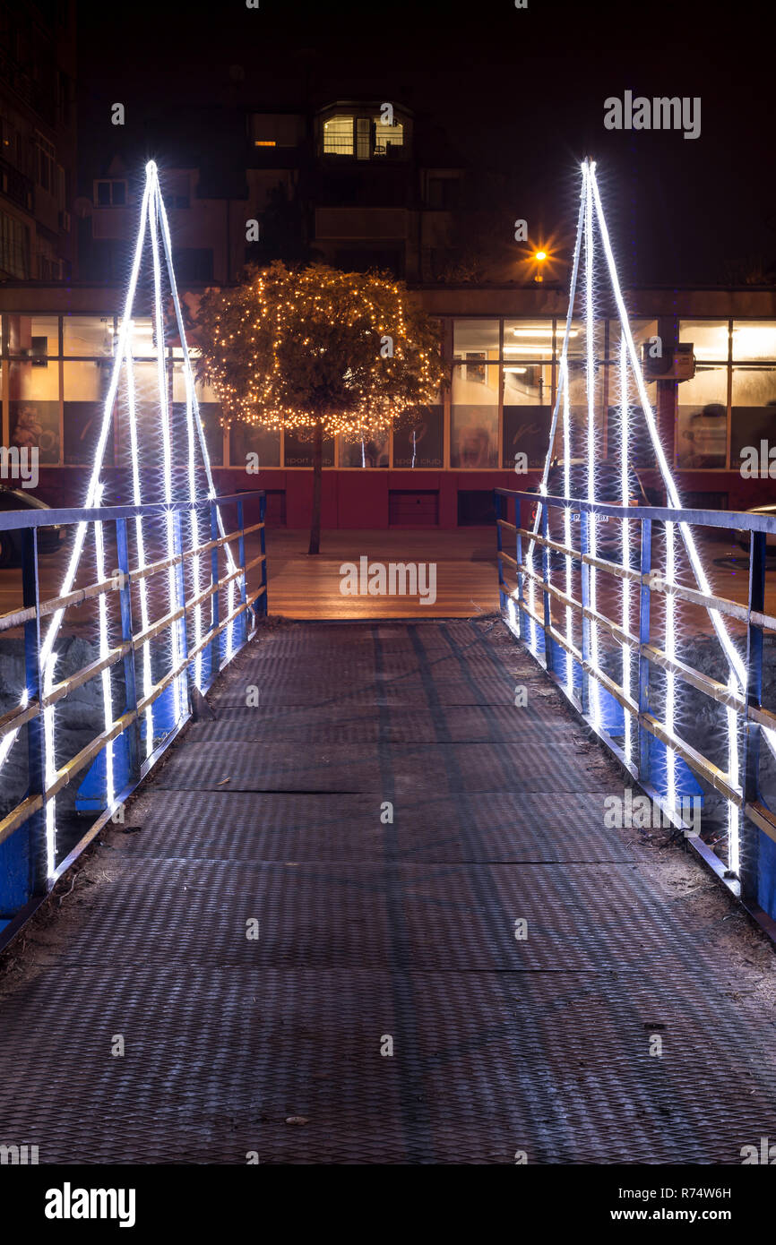 First person view of a pedestrian bridge decorated with Christmas ...