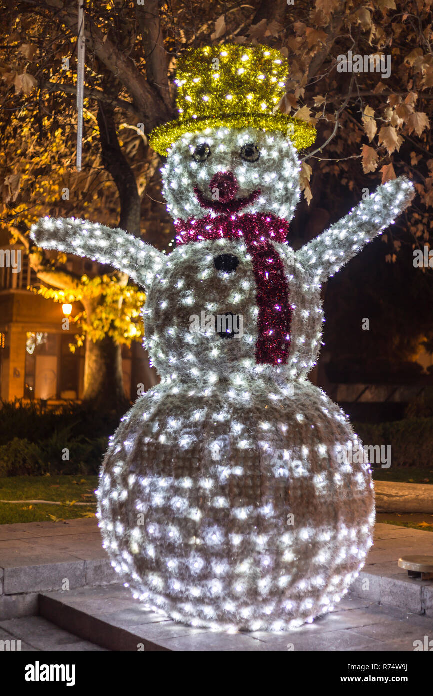 Snowman statue decorated with a lot of lights Stock Photo - Alamy