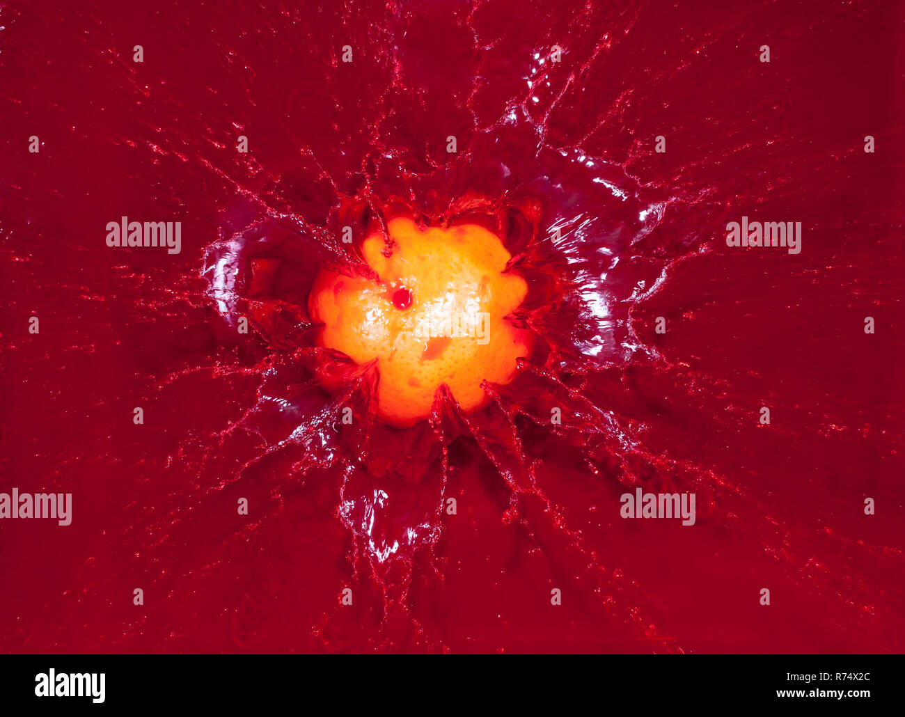 Orange tangerine falling into red water and creating a splash Stock ...