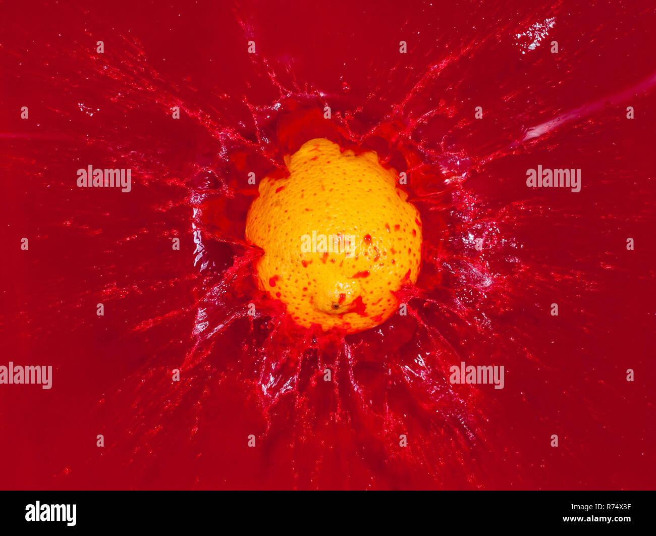 Yellow lemon falling into red water and creating a splash Stock Photo ...