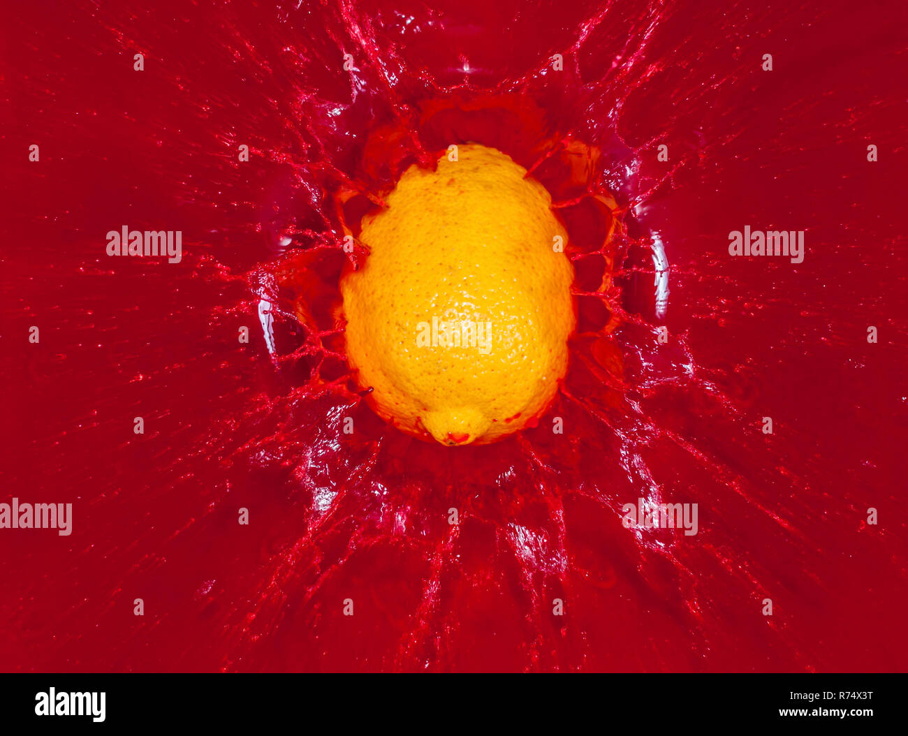 Yellow lemon falling into red water and creating a splash Stock Photo ...