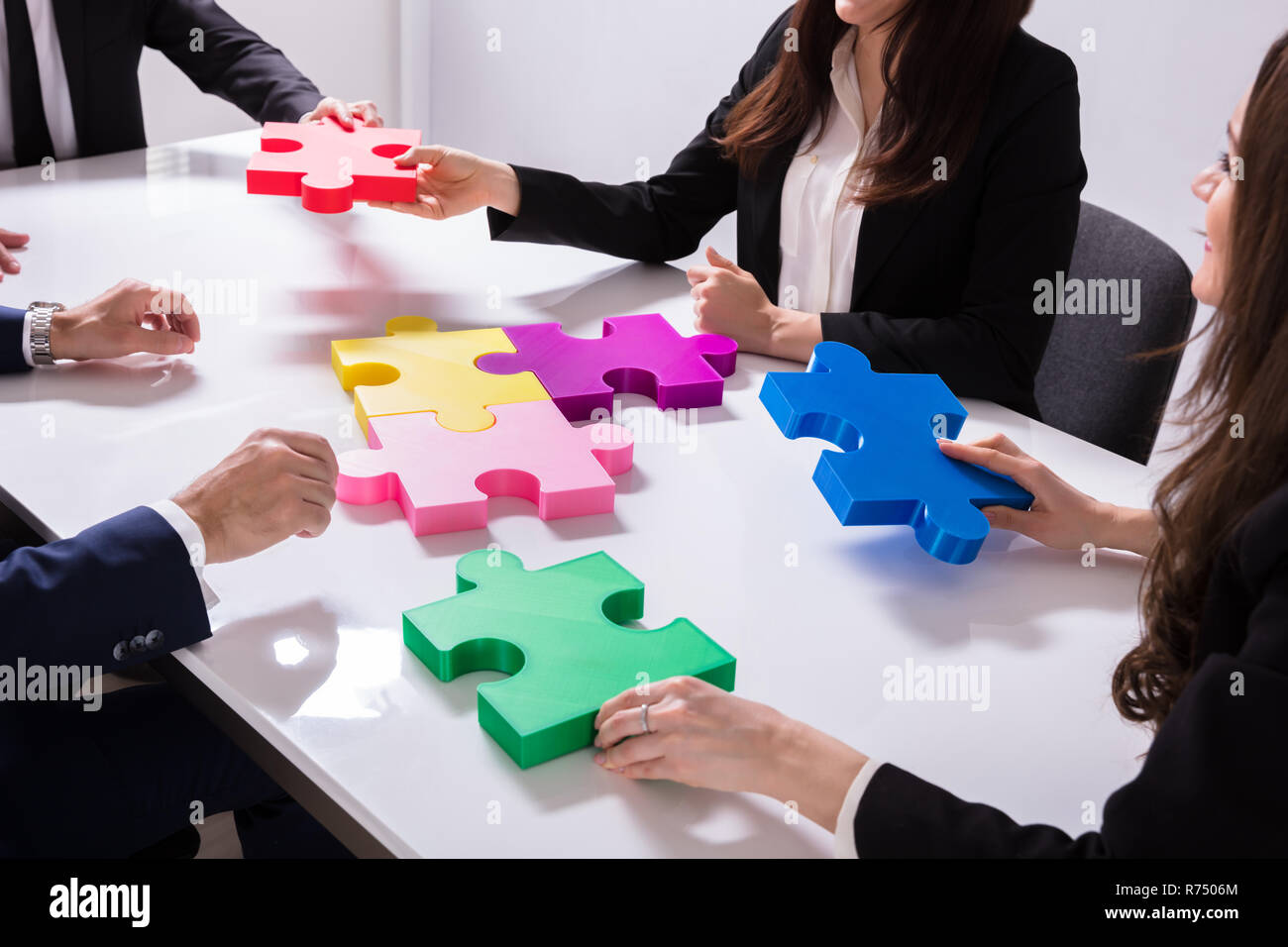 Business team with puzzle pieces office workers solve puzzle hi-res ...