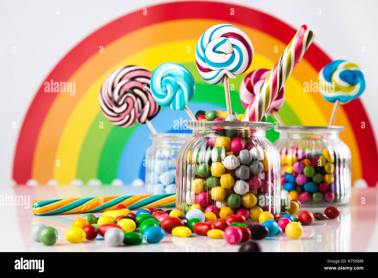 Colorful lollipops and different colored round candy and gum balls ...
