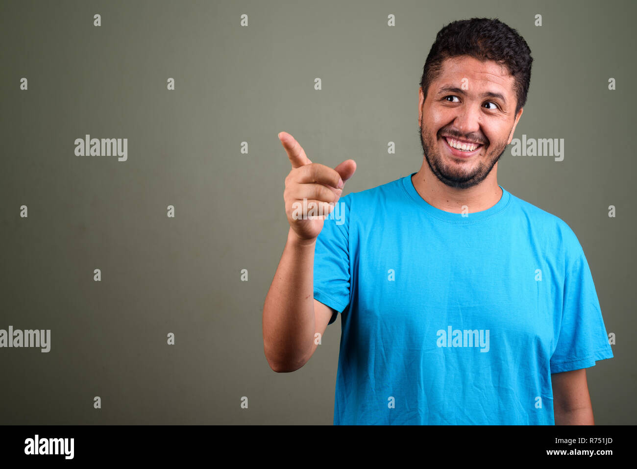 Bearded Persian man wearing blue shirt against colored backgroun Stock ...