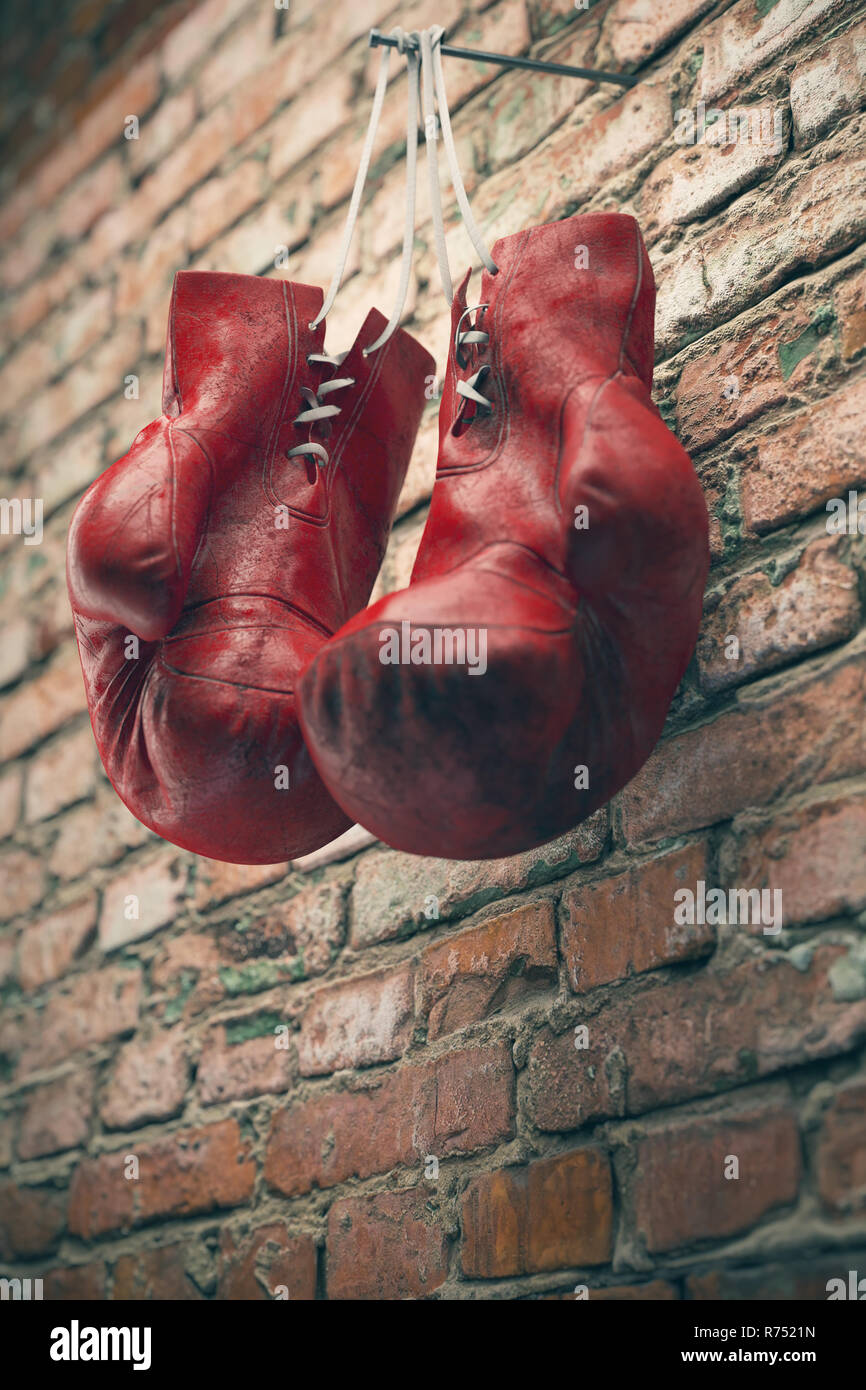 Old red boxing gloves hang on nail on brick wall with copy space for ...