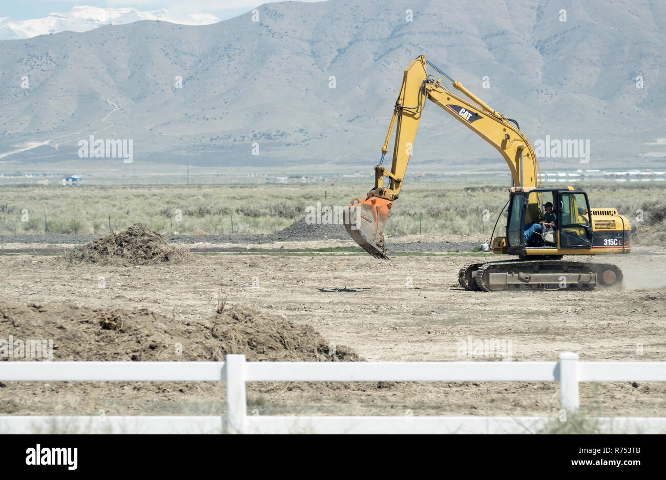 An excavator digging in the desert Stock Photo - Alamy