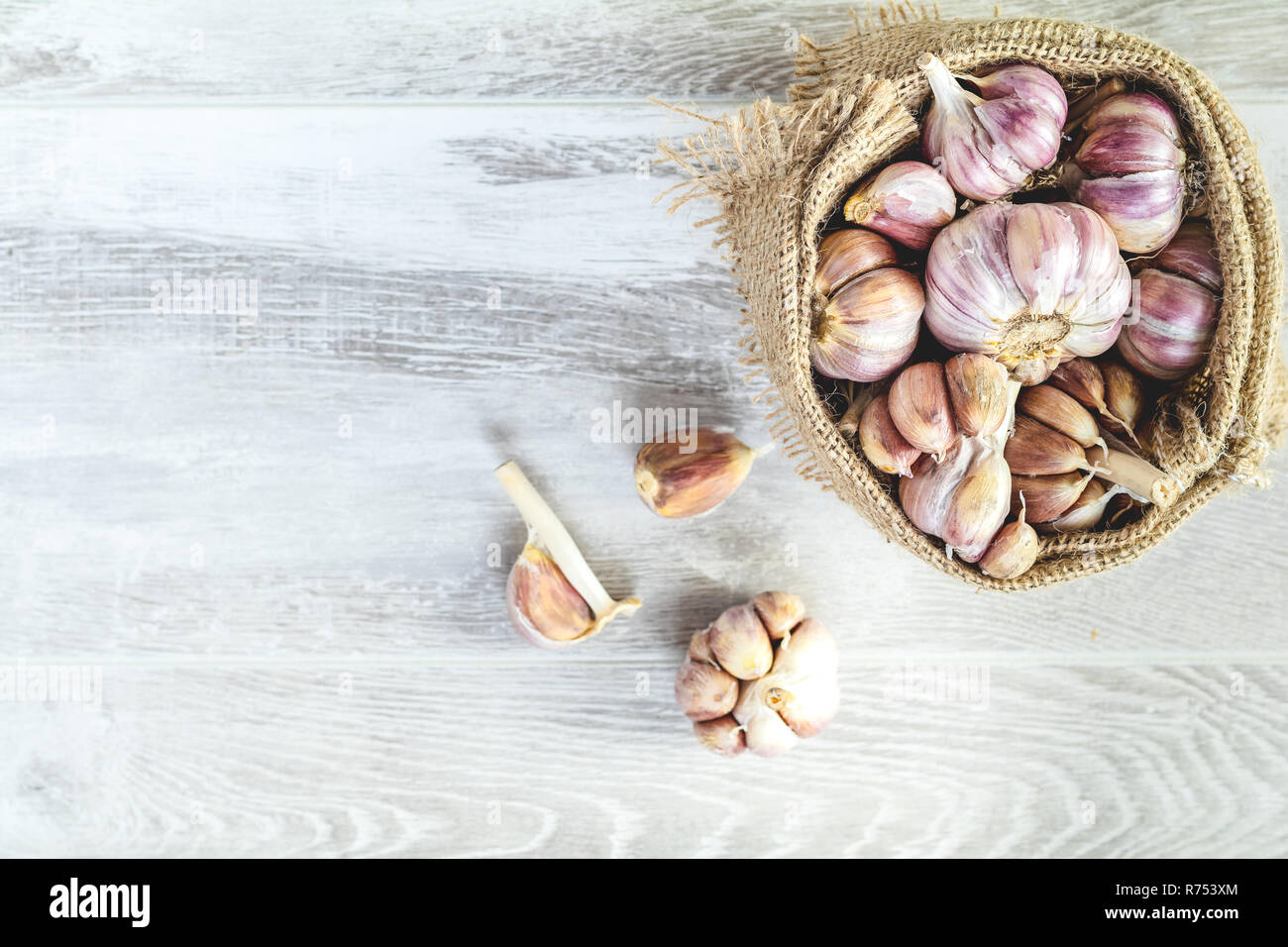 Garlic in a sack of old cloth. Fresh garlic on a light gray wooden ...