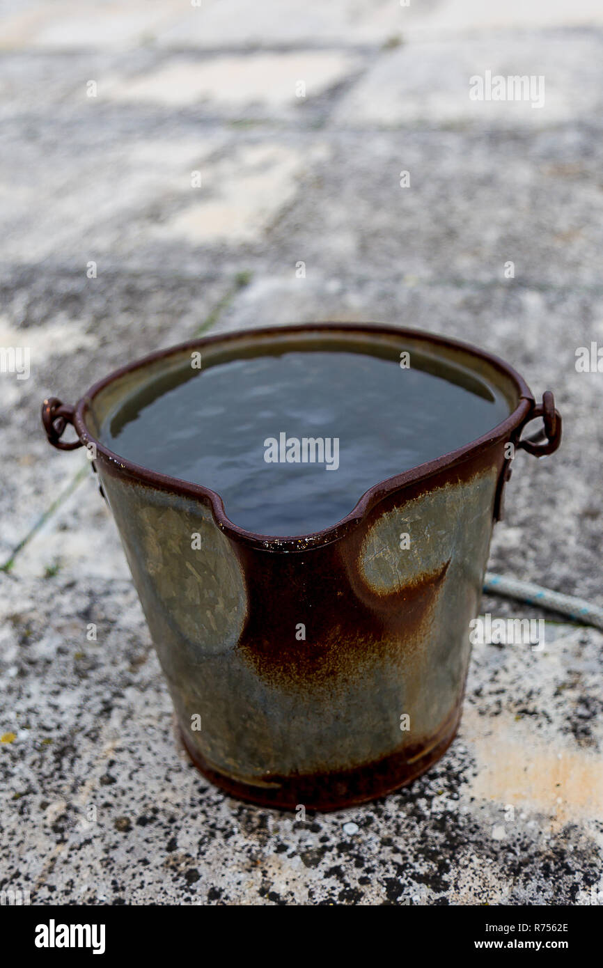 Old Rusty Metal Bucket Filled With Water From The Rain Stock Photo - Alamy