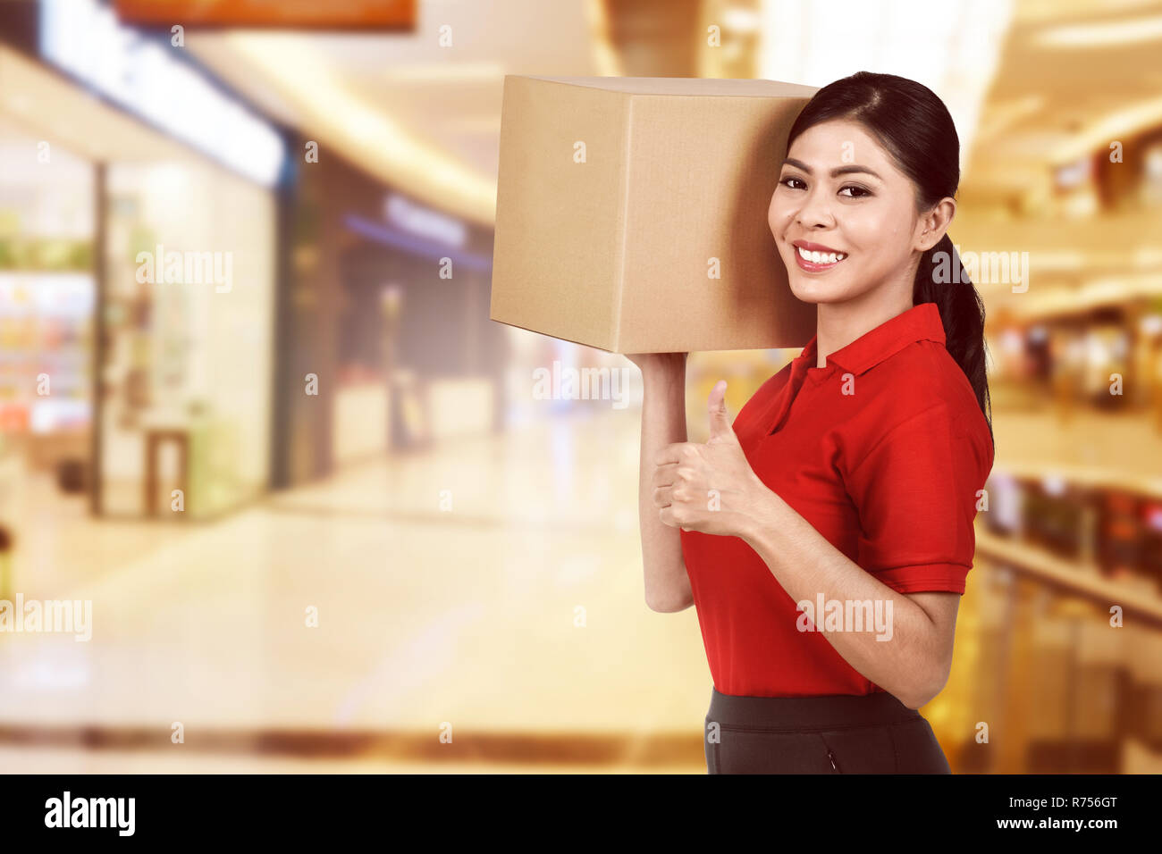 Beautiful asian female delivery holding the package Stock Photo - Alamy
