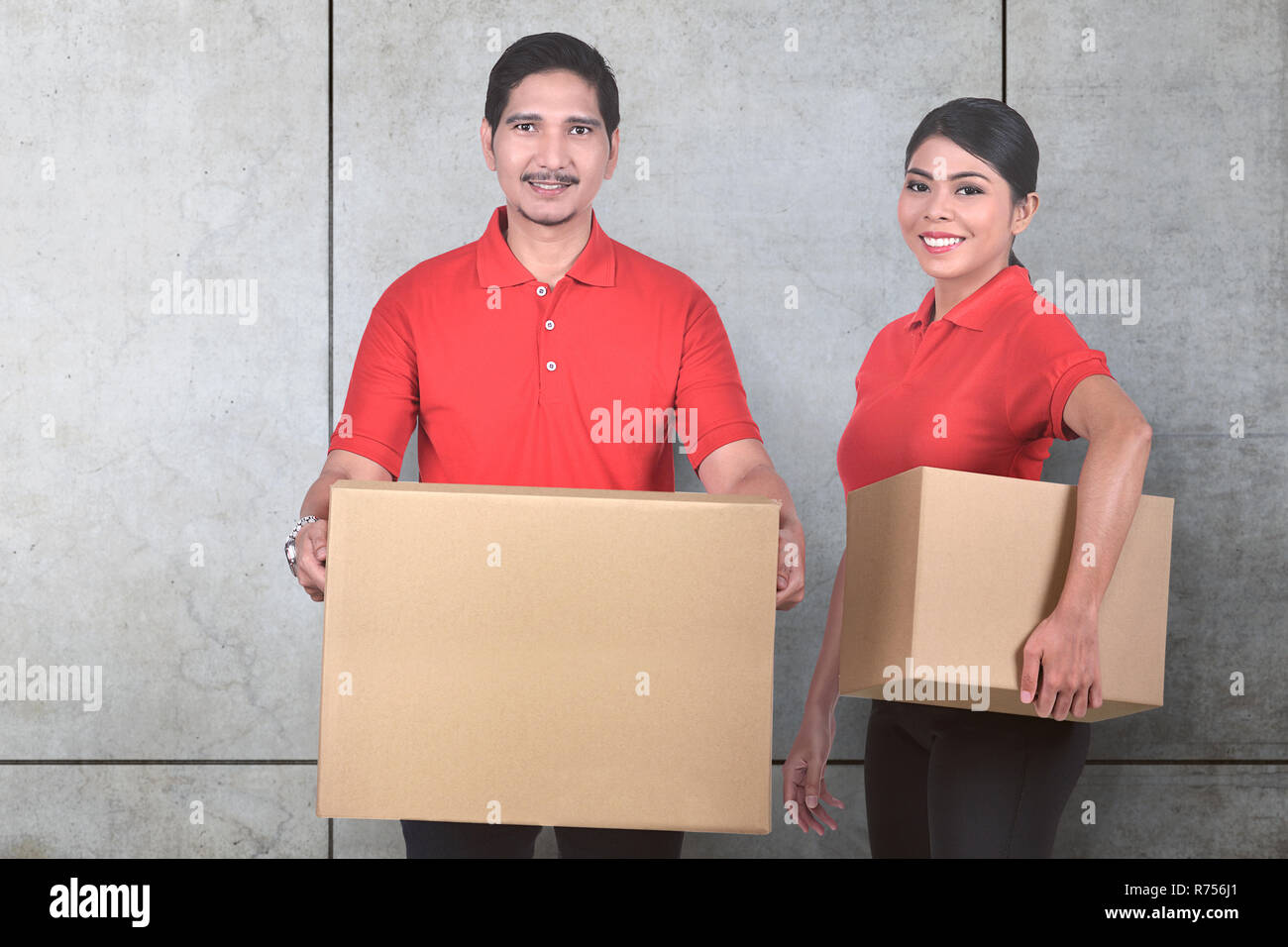 Young asian delivery service team with the parcel standing Stock Photo ...