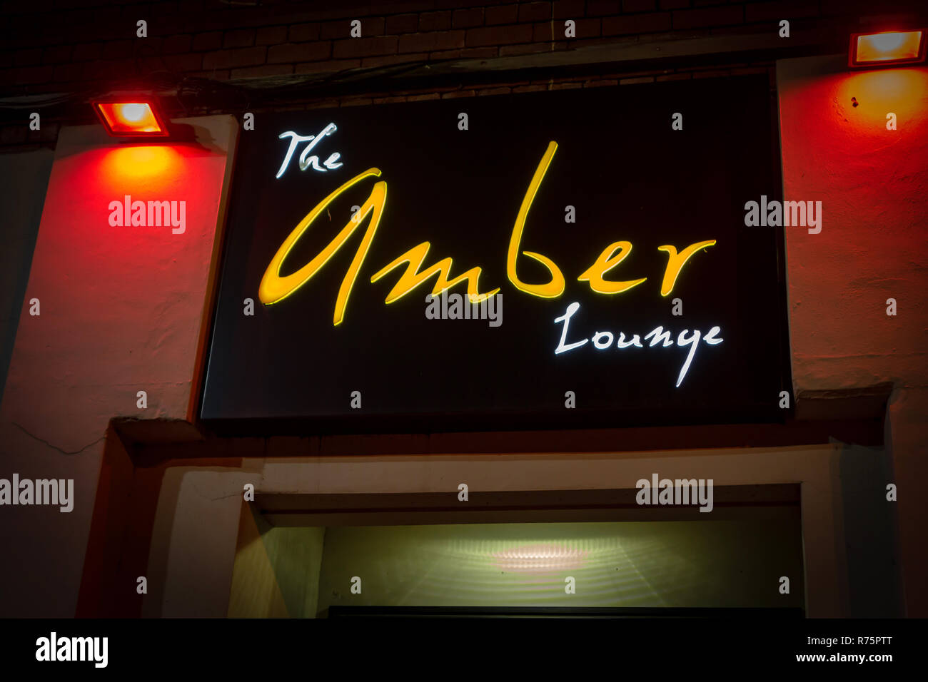 An illuminated sign at night for The Amber Lounge is one of the many ...