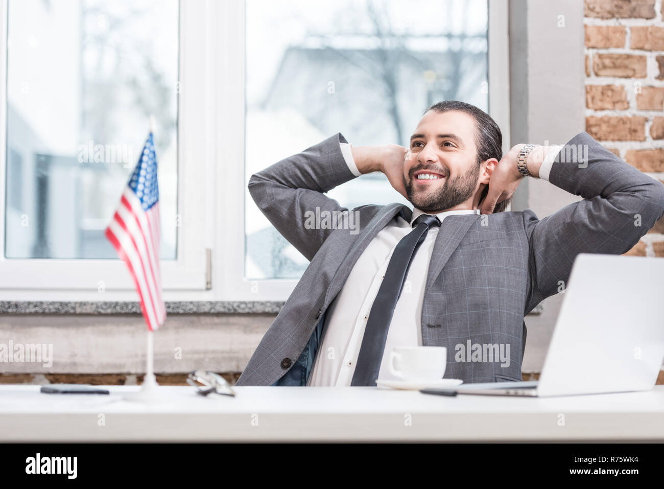 successful businessman with hands on head sitting at office desk Stock ...