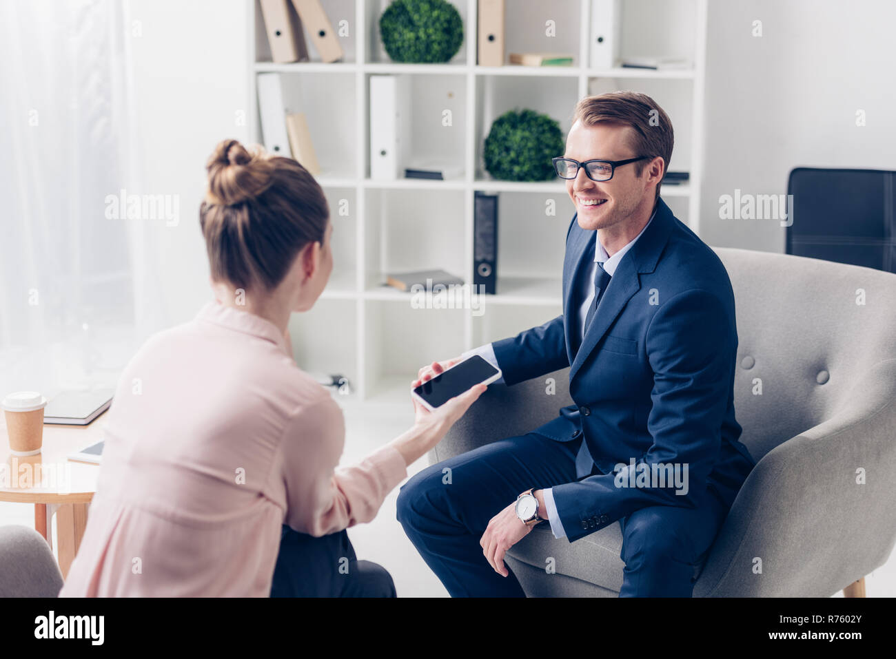 happy handsome businessman giving interview to journalist in office ...