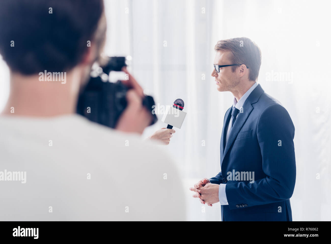 selective focus of handsome businessman in glasses giving video ...