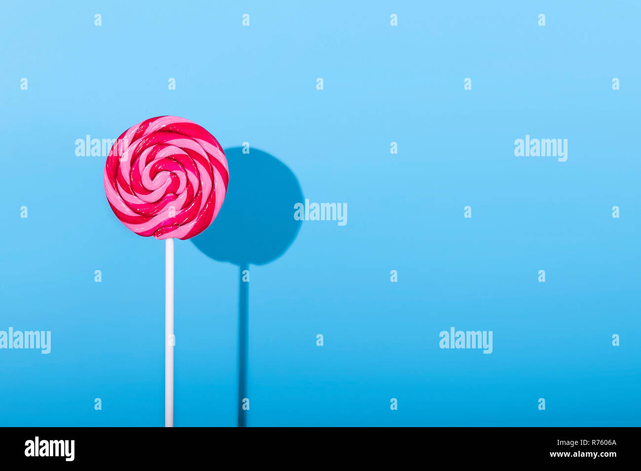 Pink Lolipop candy with shadow on pastel blue background Stock Photo ...
