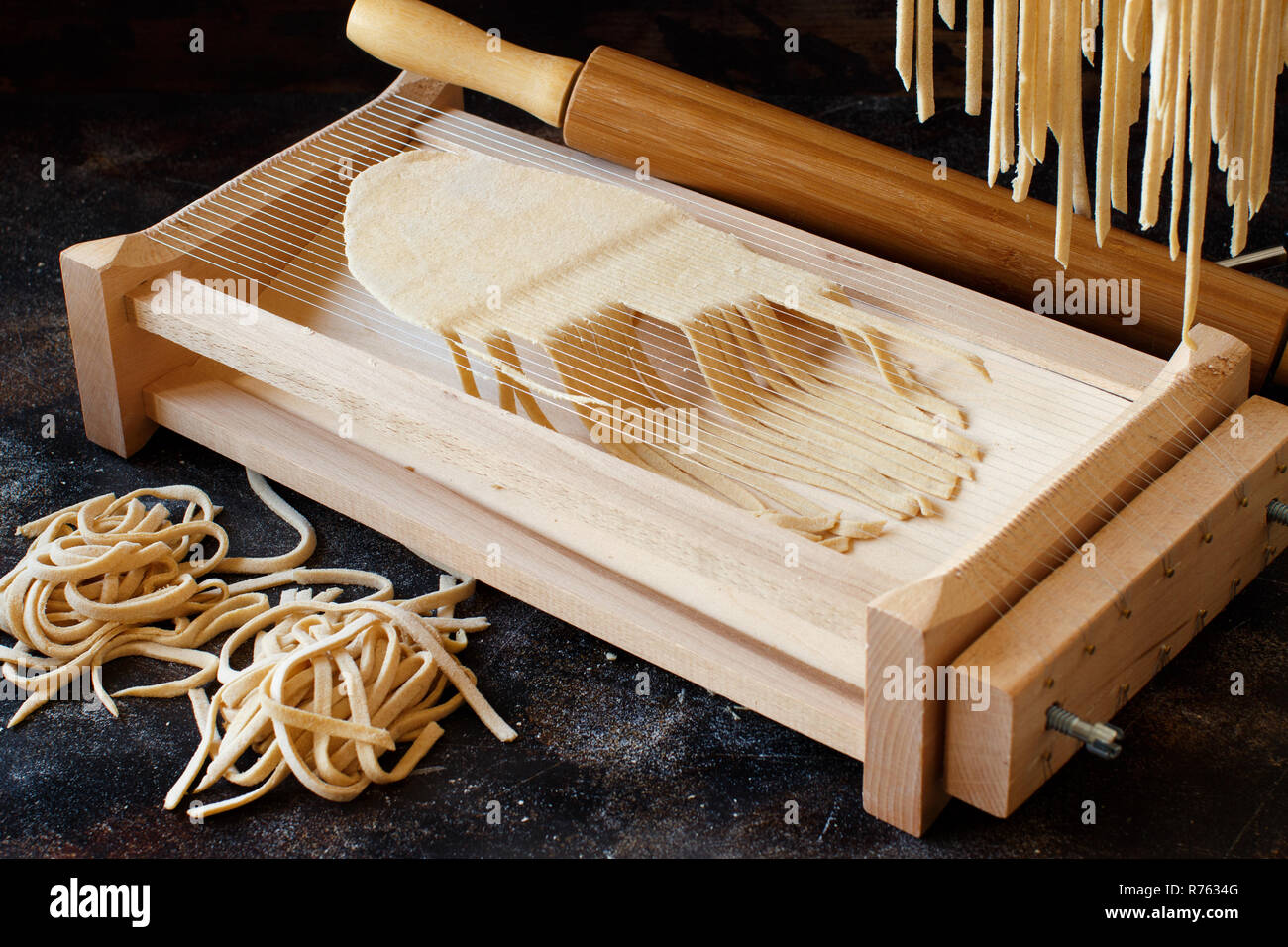 Making tagliolini pasta alla chitarra with a tool Stock Photo - Alamy