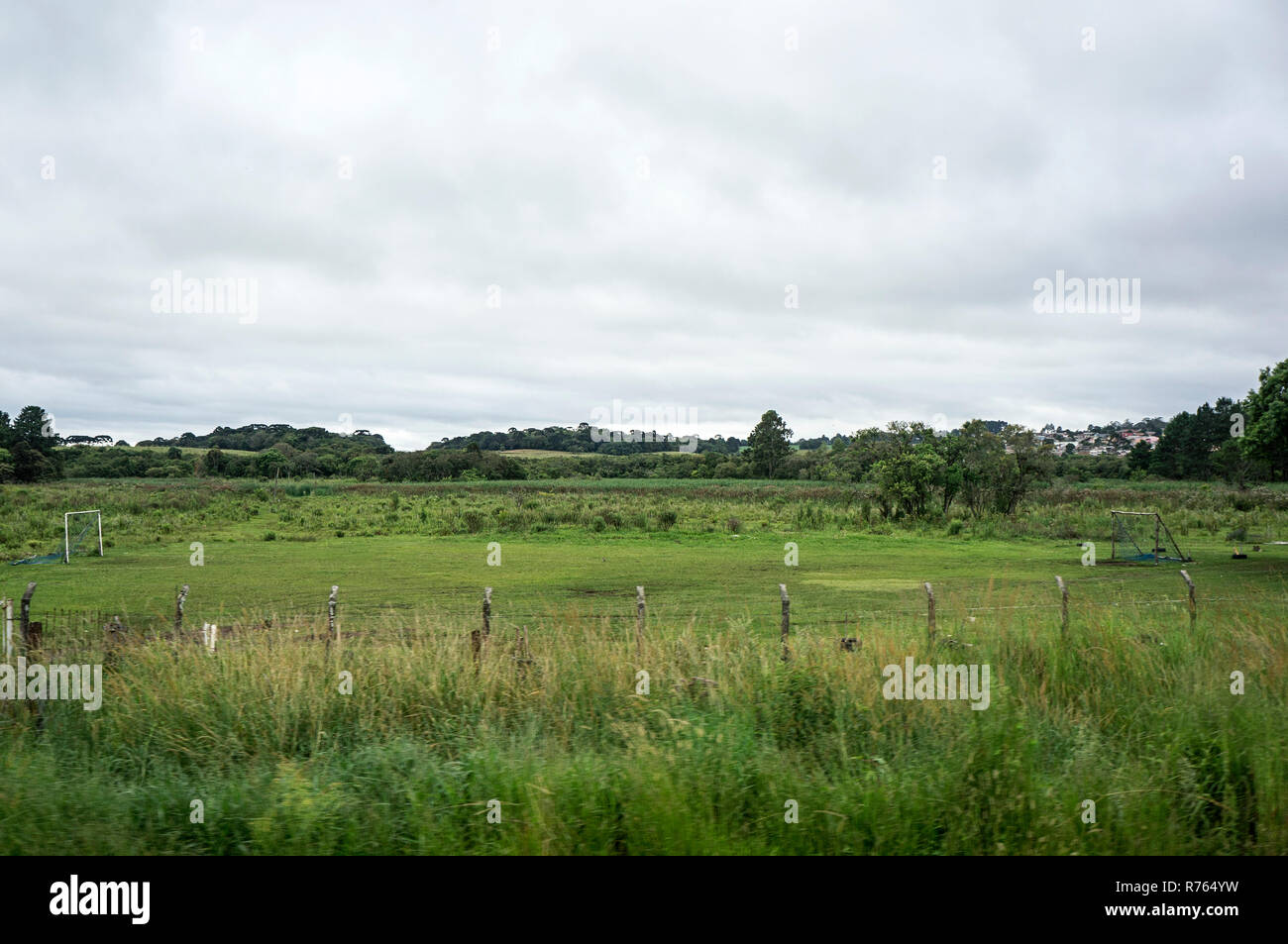 football field outdoors tall bush fence rural Stock Photo - Alamy