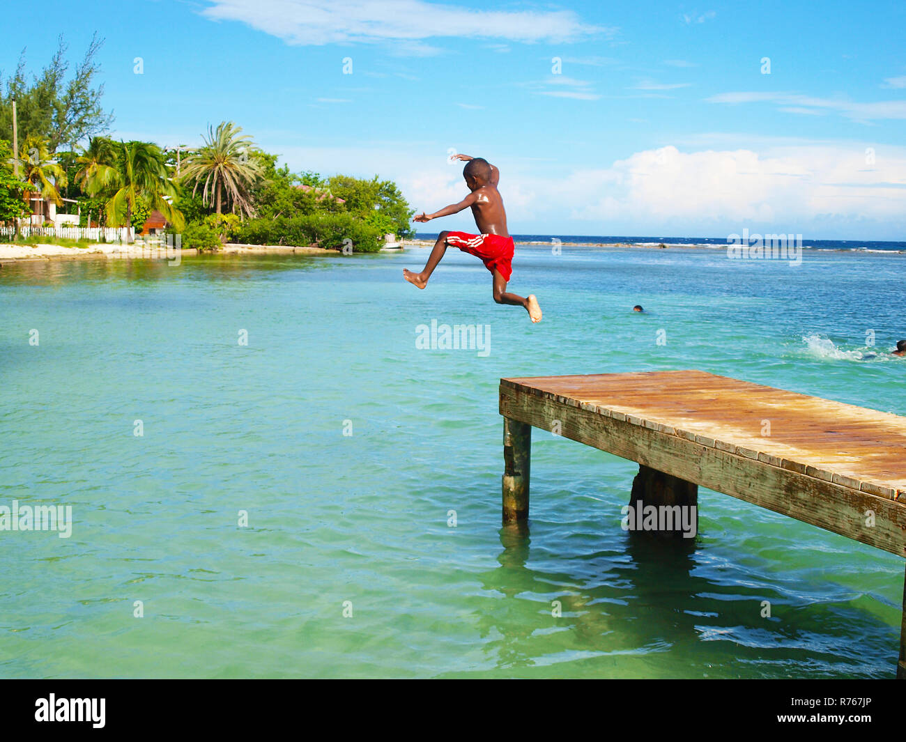 Boy Jumping into water, Oak Ridge, Roatan Stock Photo - Alamy