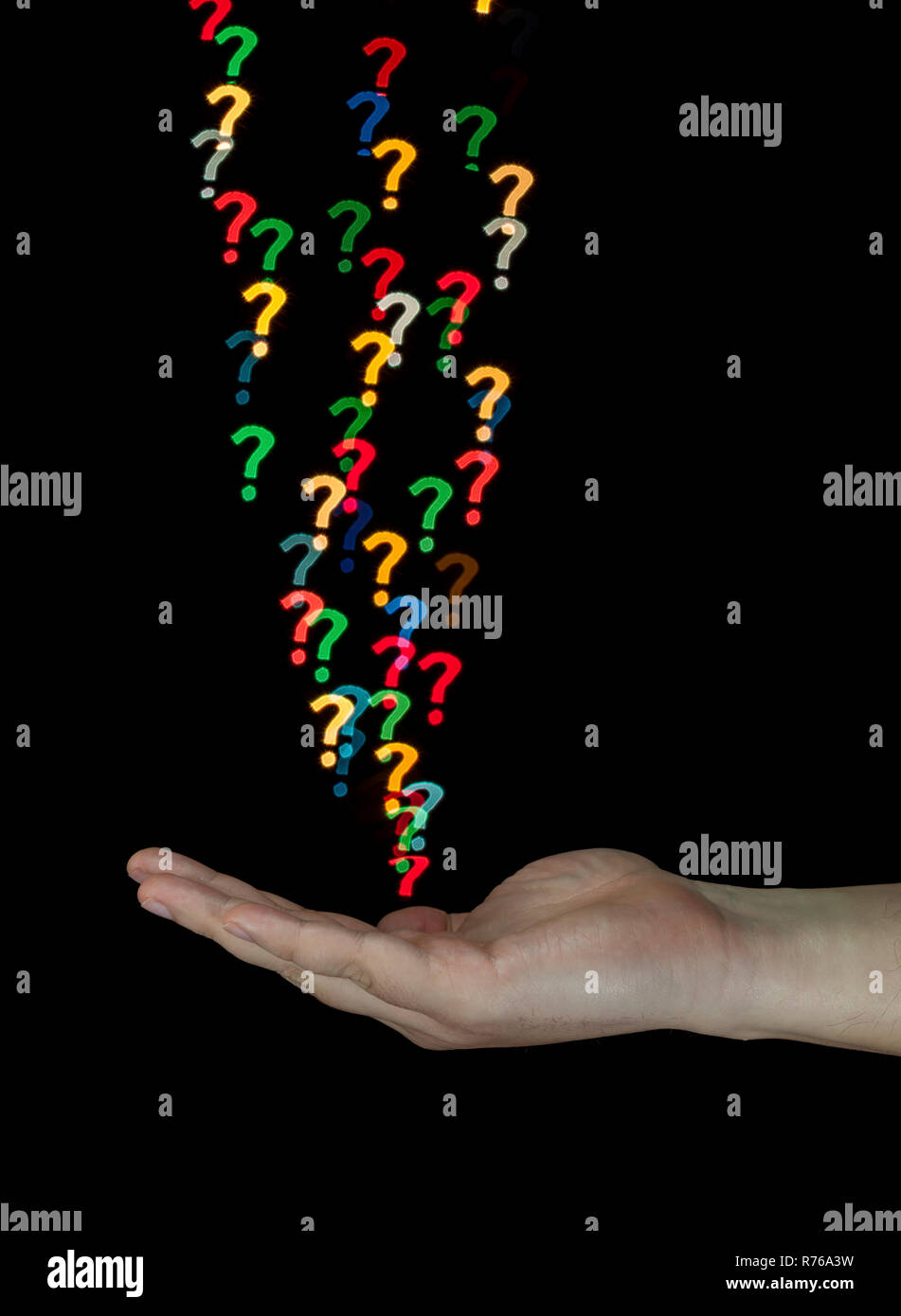 Human hand catching bokeh question marks created from decoration lights ...