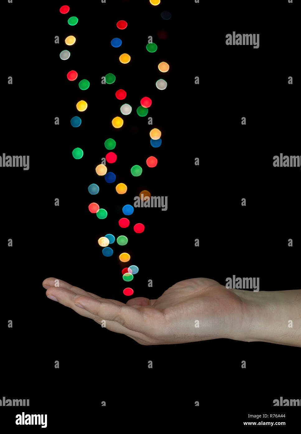 Human hand catching light bokeh bubbles. Isolated on black background ...