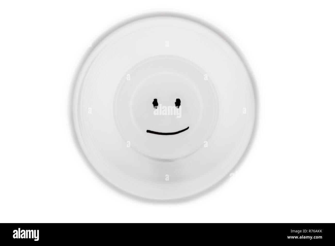 White plastic cup with a smiley face on the bottom Stock Photo - Alamy