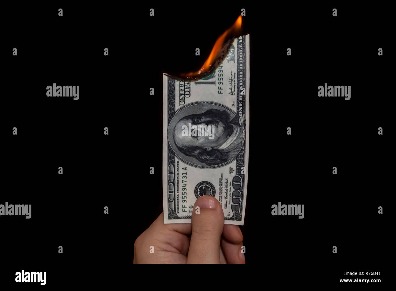 Human hand holding a burning 100 dollar bill Stock Photo - Alamy