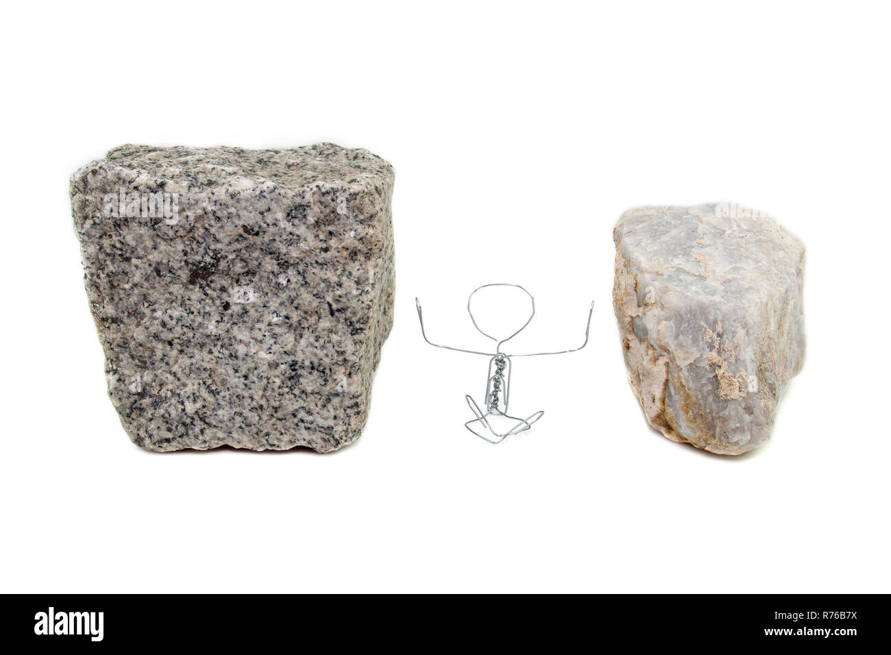 A paperclip figure sitting between paving stone and a marble stone ...