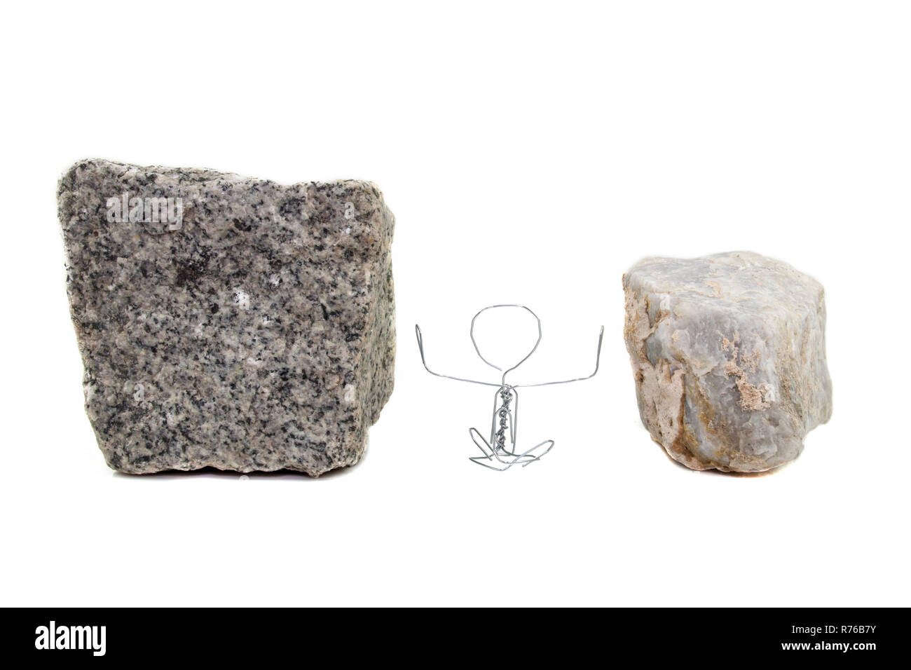 A paperclip figure sitting between paving stone and a marble stone ...