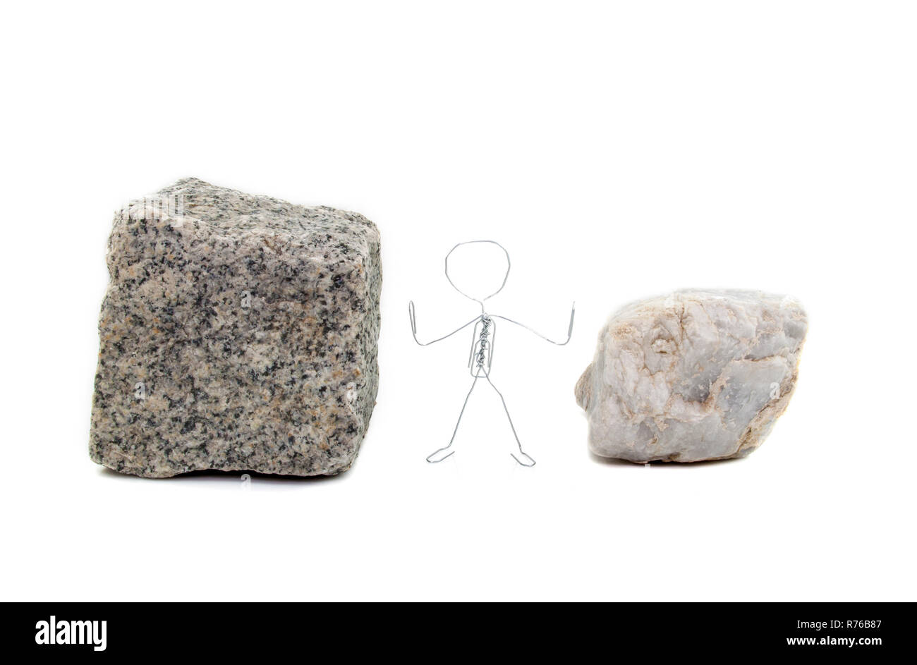 A paperclip figure standing between paving stone and a marble stone ...