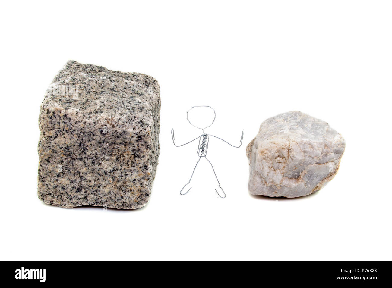 A paperclip figure standing between paving stone and a marble stone ...