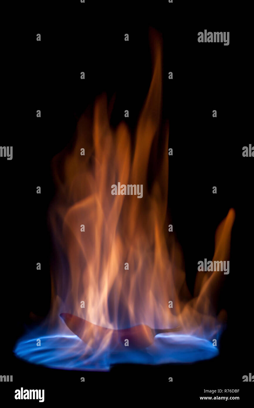 Hot pepper burning in blue flames Stock Photo - Alamy