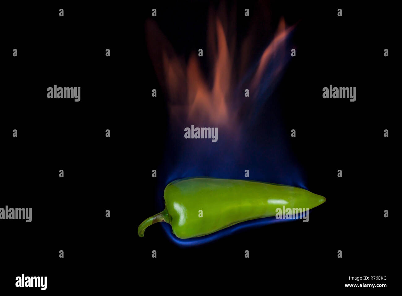 Green Pepper on fire with blue flames isolated on black background ...