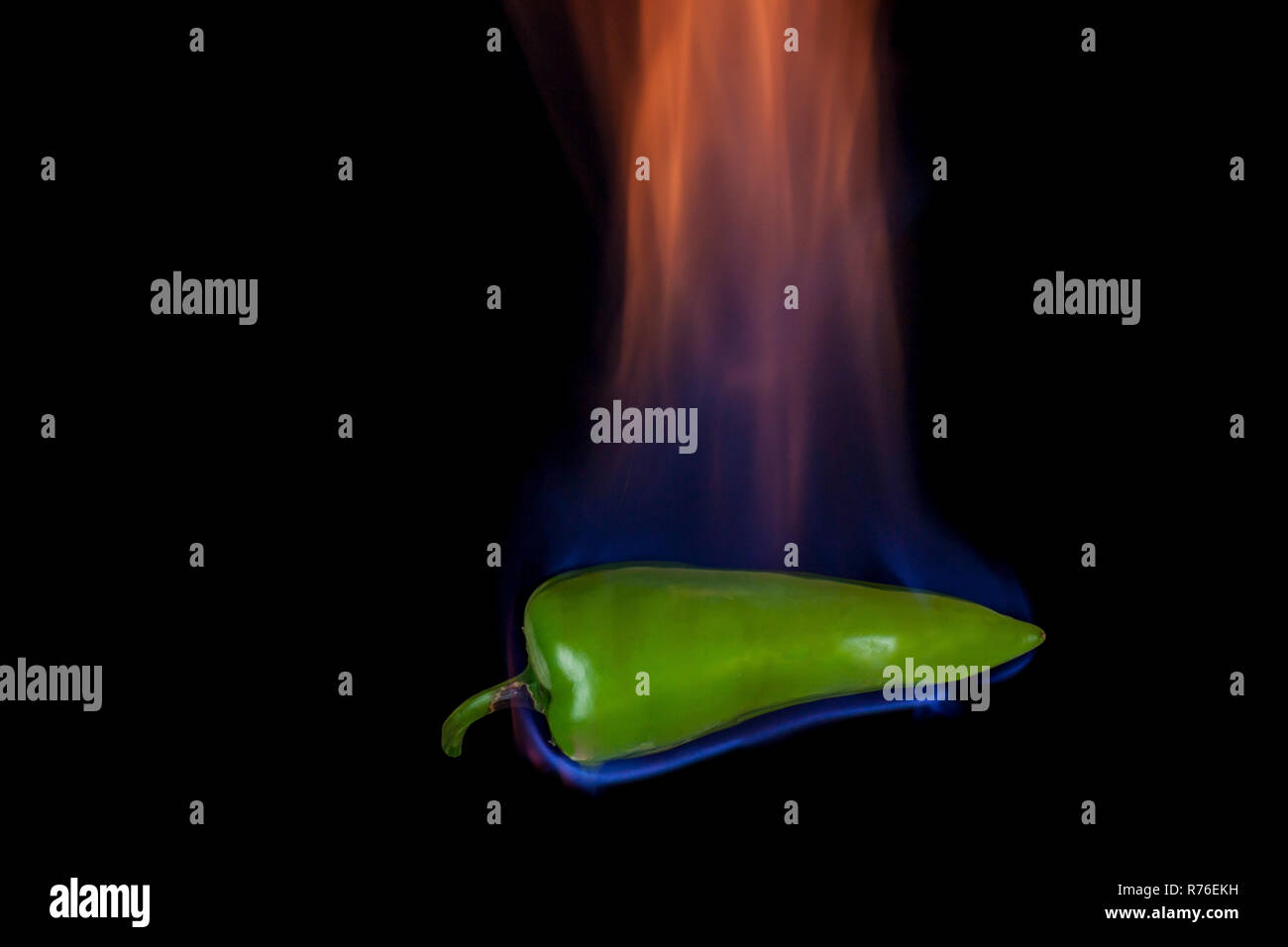 Green Pepper on fire with blue flames isolated on black background ...