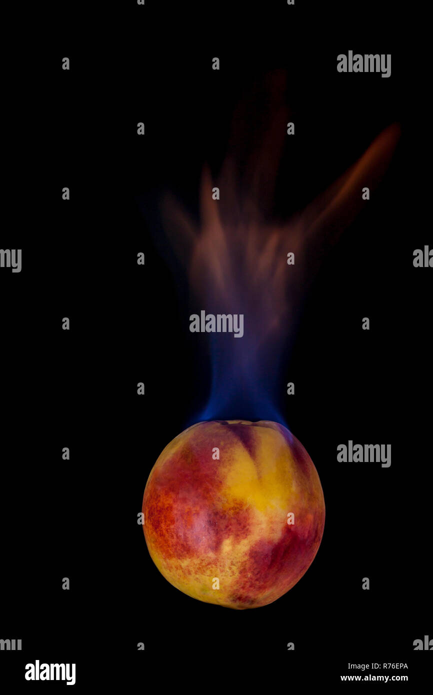 Peach on fire with blue flames isolated on black background Stock Photo ...