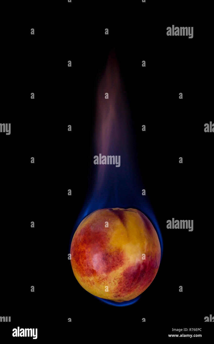 Peach on fire with blue flames isolated on black background Stock Photo ...
