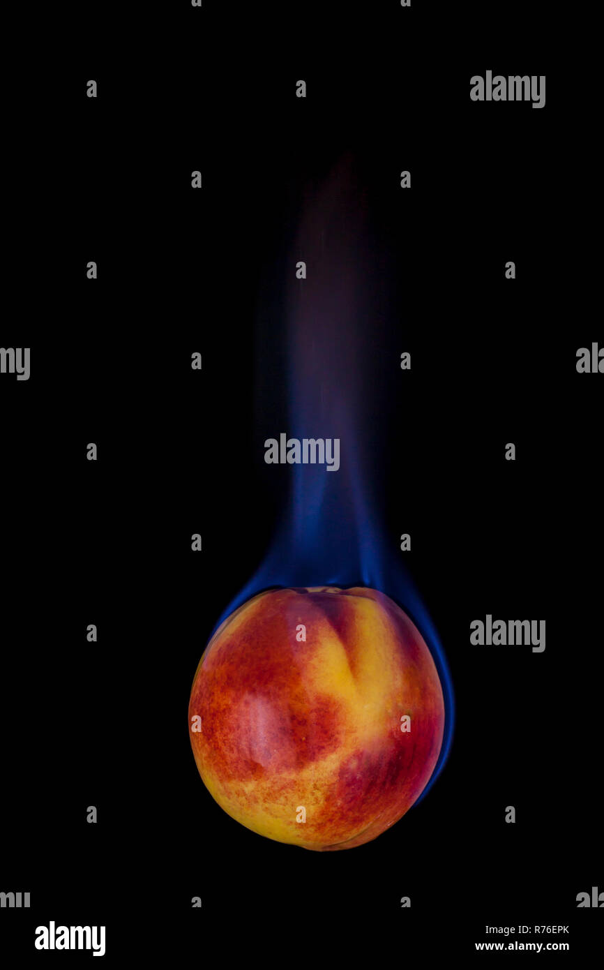 Peach on fire with blue flames isolated on black background Stock Photo ...