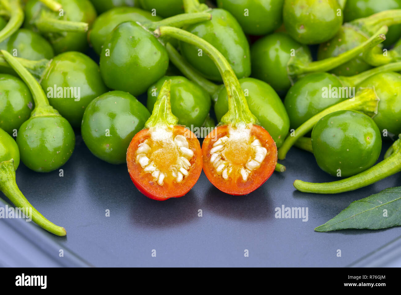 Cherry peppers with half-cut red with green. scinentific name is ...