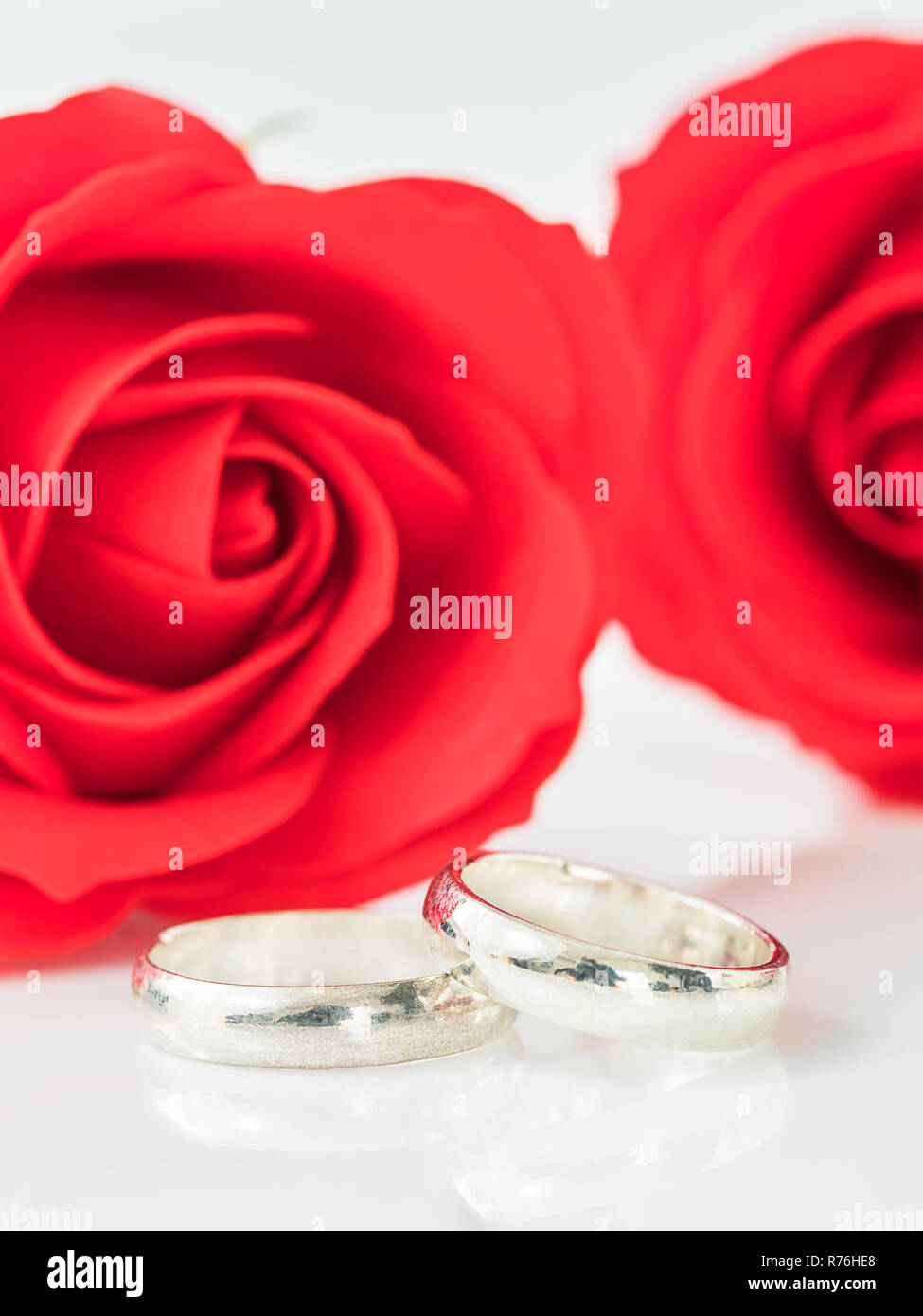 Red rose and wedding ring on white Stock Photo - Alamy
