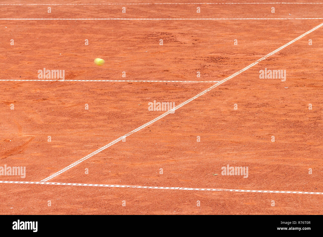 Tennis ball flying in mid air on a clay court Stock Photo - Alamy