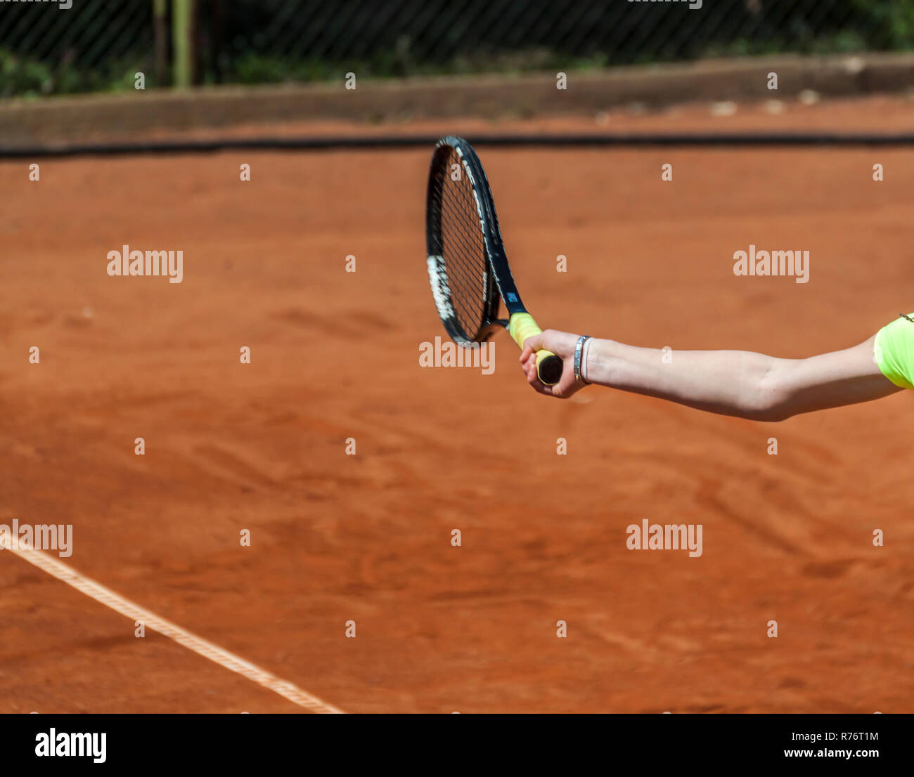Human hand holding a tennis racket and preforming a forehand strike ...