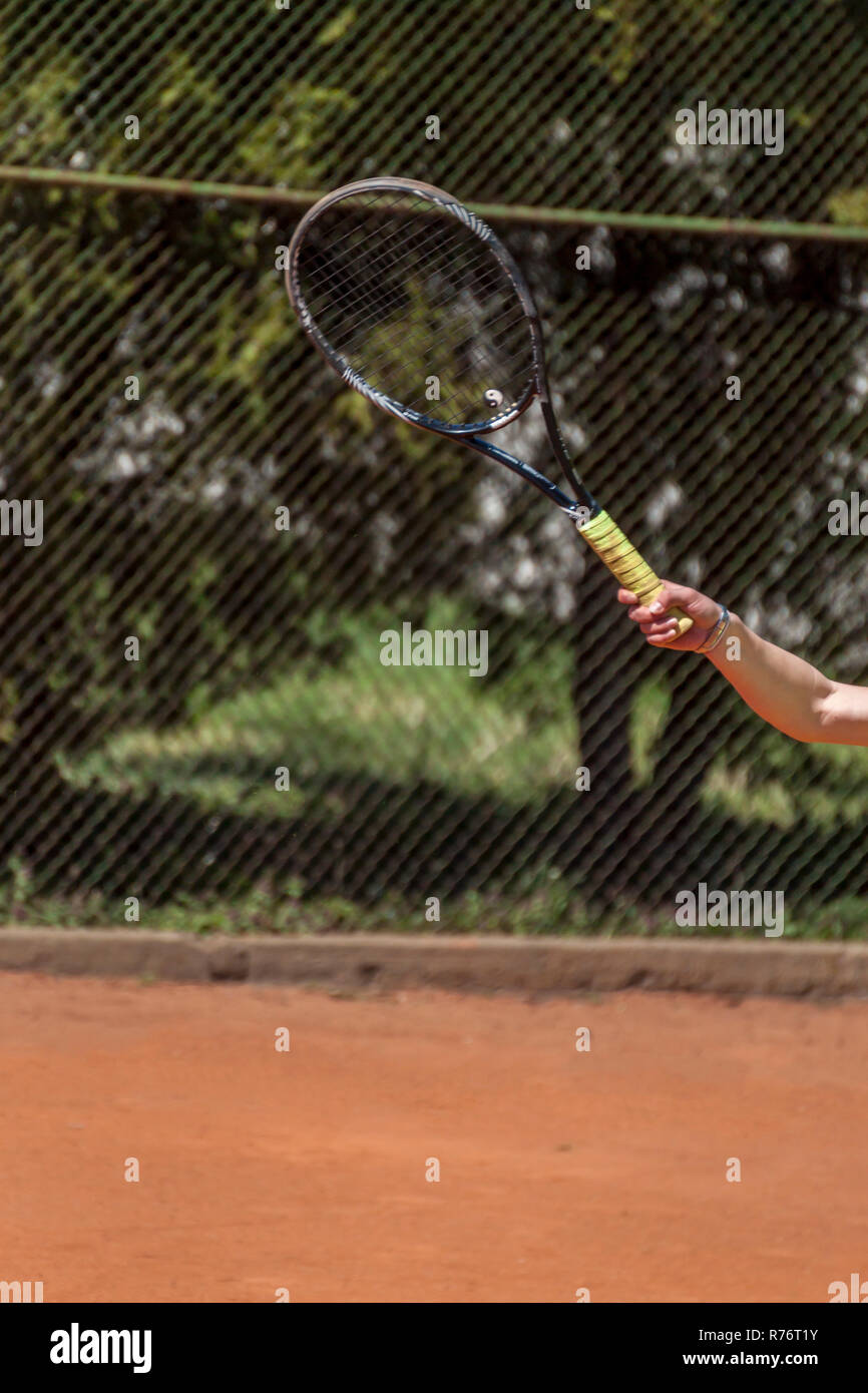 Human hand holding a tennis racket and preforming a forehand strike ...