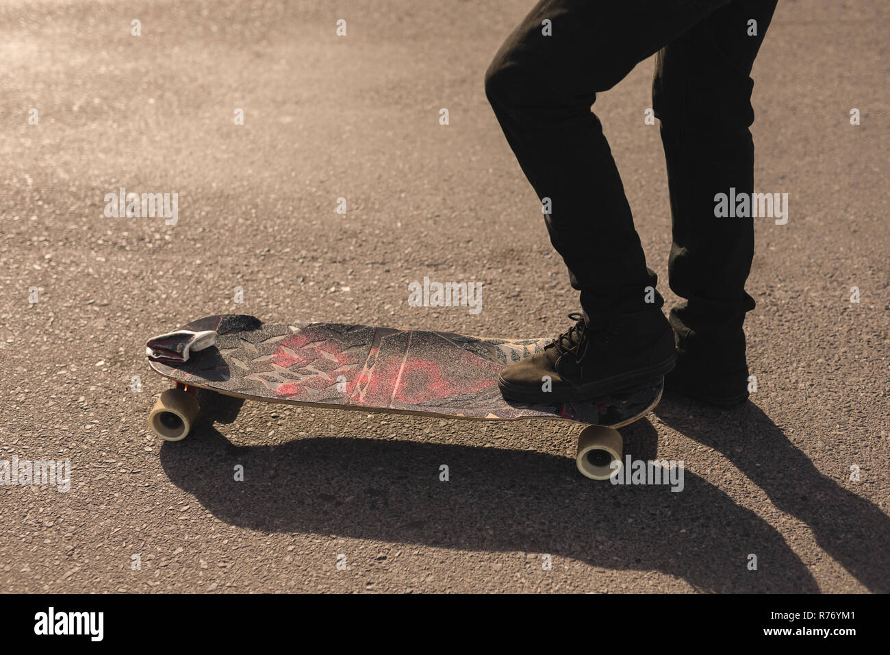 Skateboarder skating on country road Stock Photo - Alamy