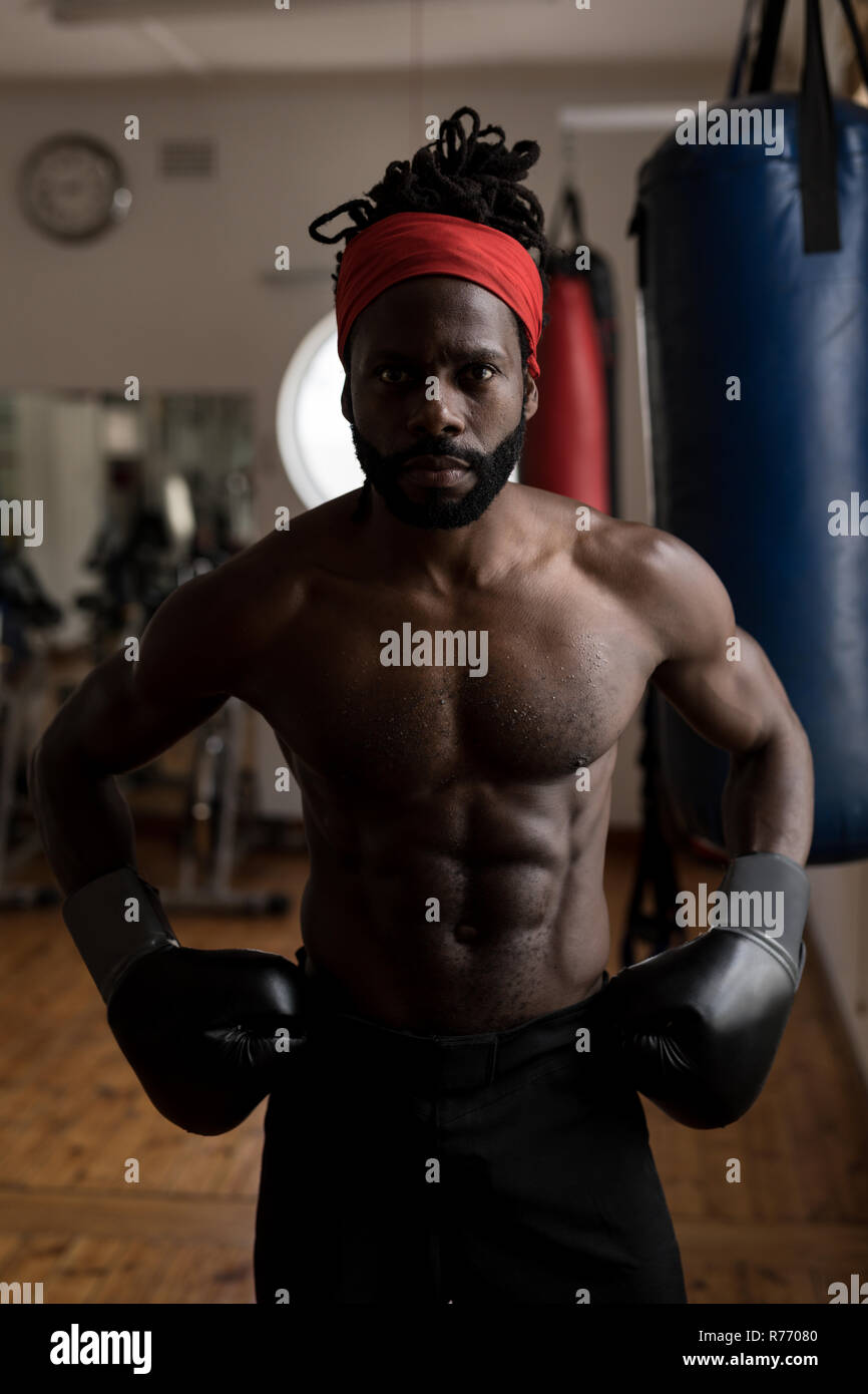 Male boxer standing with hands on hips in fitness studio Stock Photo ...