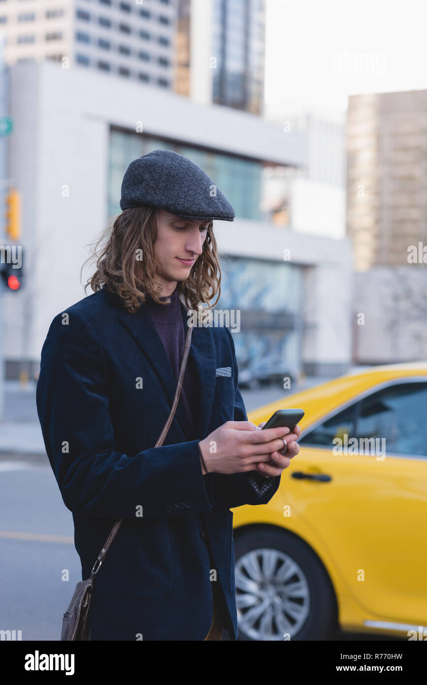 Man using mobile phone while walking on the street Stock Photo - Alamy